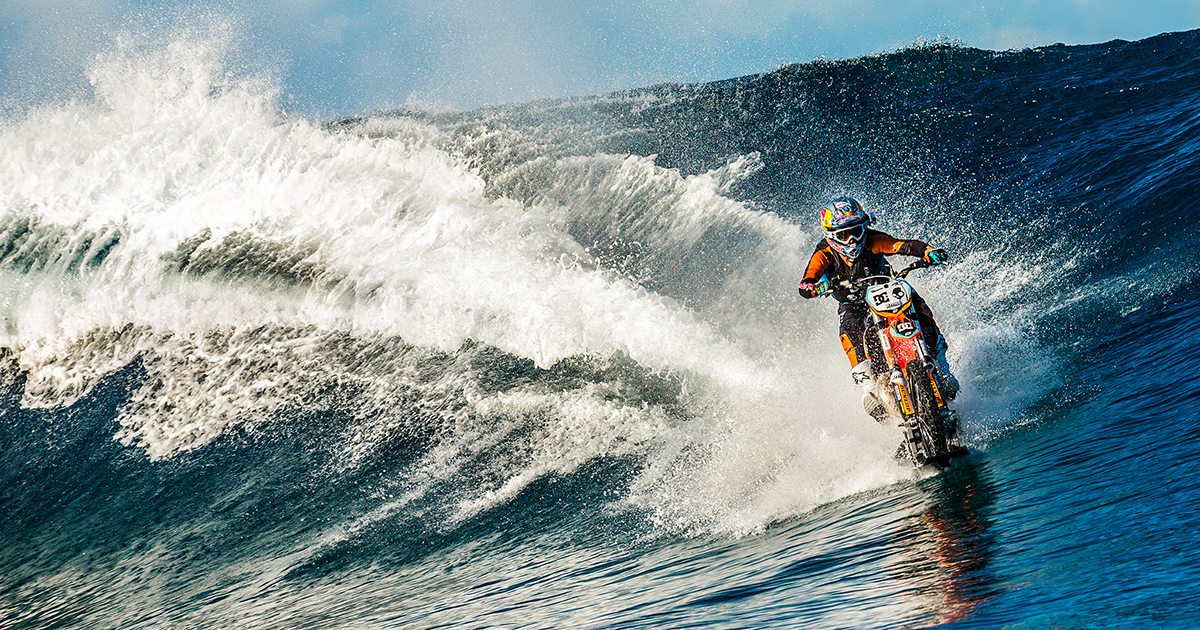 This daredevil is using his dirt bike to surf the waves.