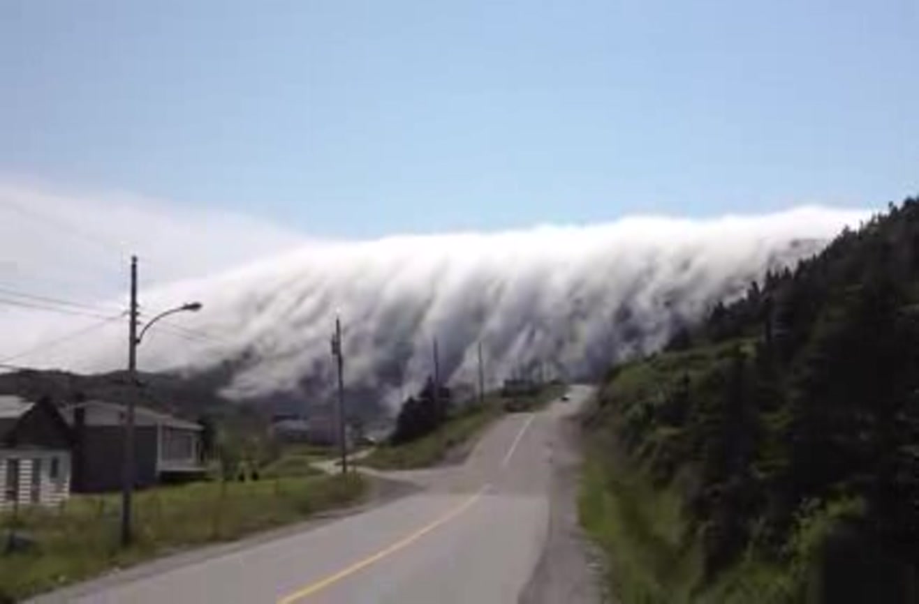 Breathtaking tidal wave of fog rolling over Newfoundland mountains.