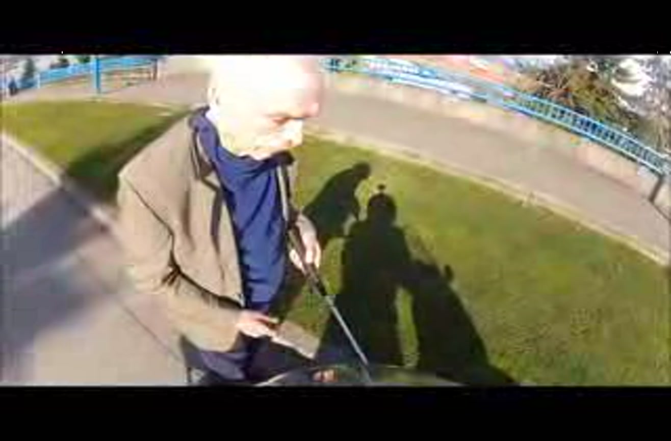 Biker helps blind man safely off busy road.