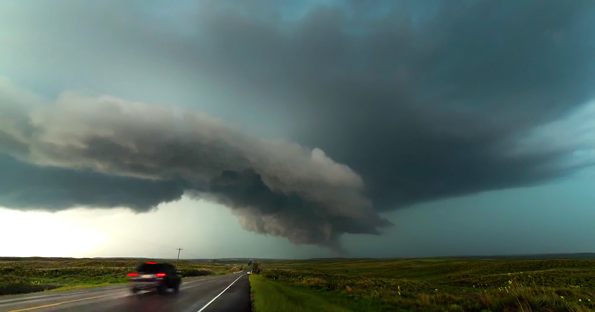 Along the quiet plains, a raging storm's grace is captured by a ...