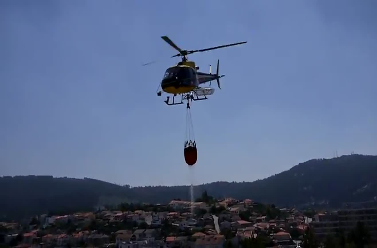 Helicopter borrows pool water to douse fire.
