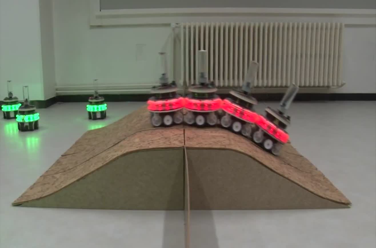 Swarm robots cooperate with a flying drone.