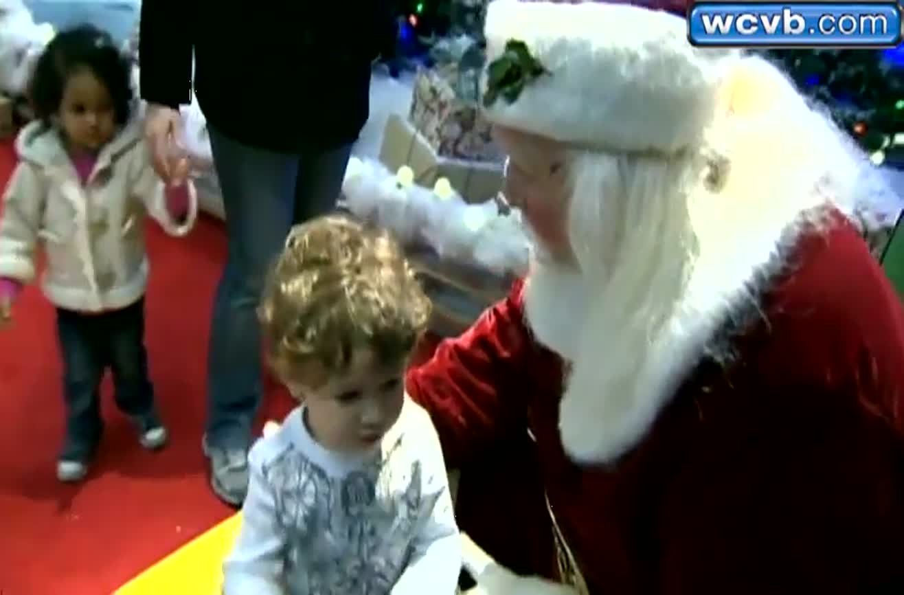 Santa uses sign language with deaf child.