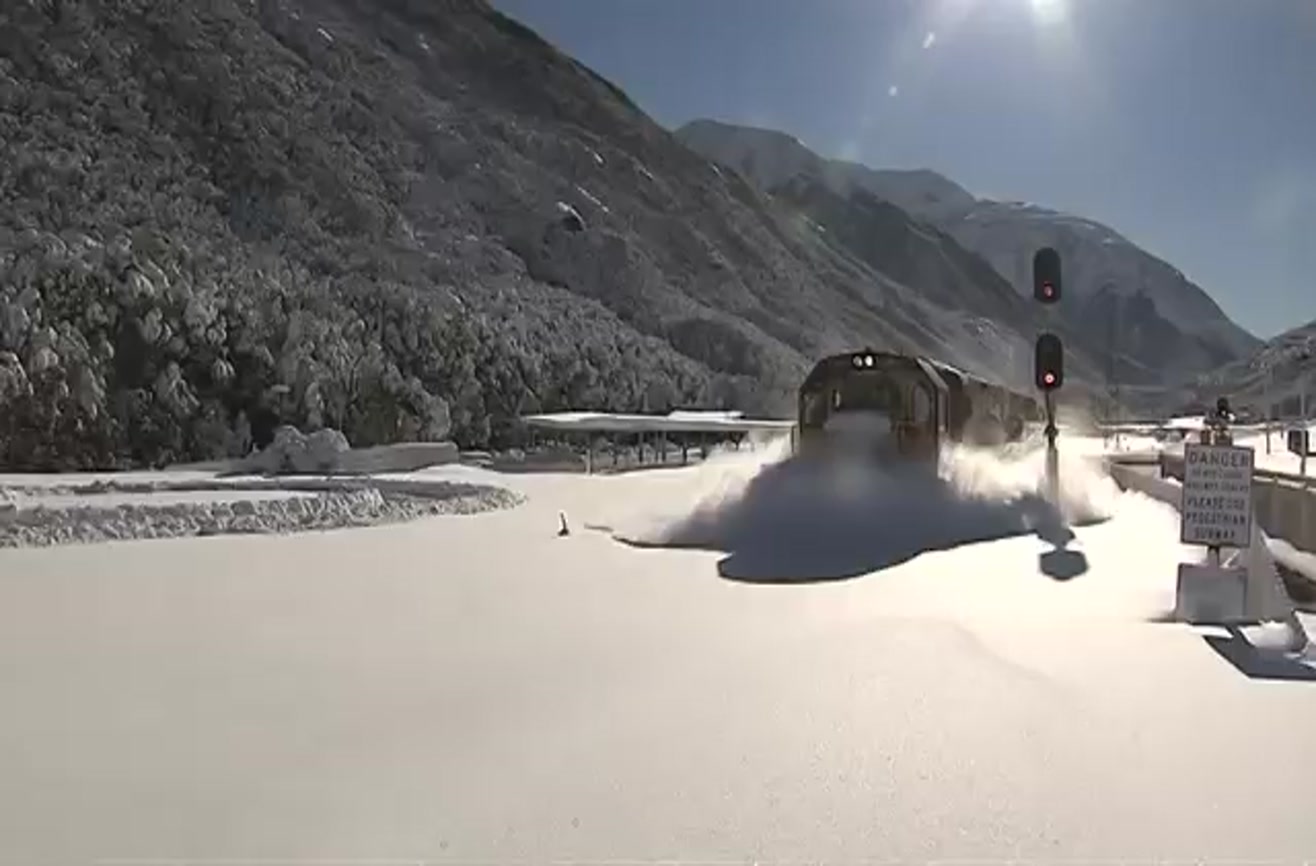 Train plows through snow-covered tracks.