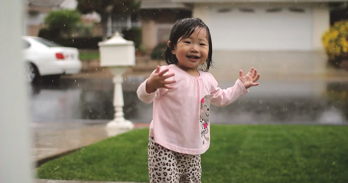 A little girl experiences rain for the very first time.
