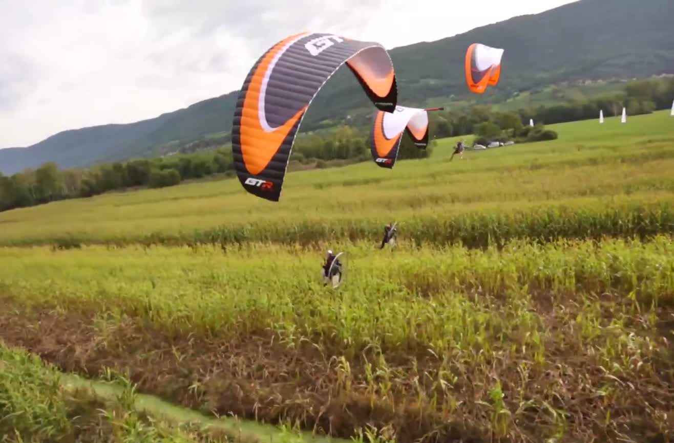 Engine-powered paragliders racing through the French Alps.