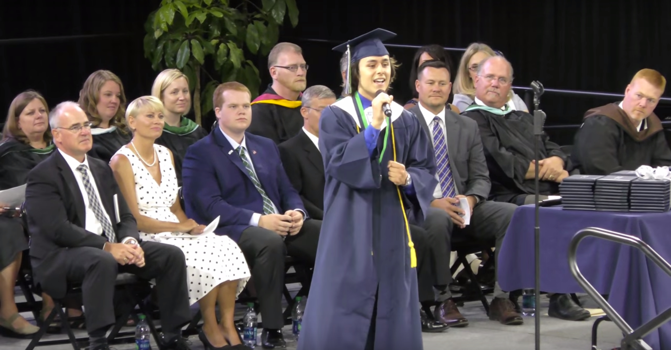 High school student sings his own rendition of "7 Years" at graduation.