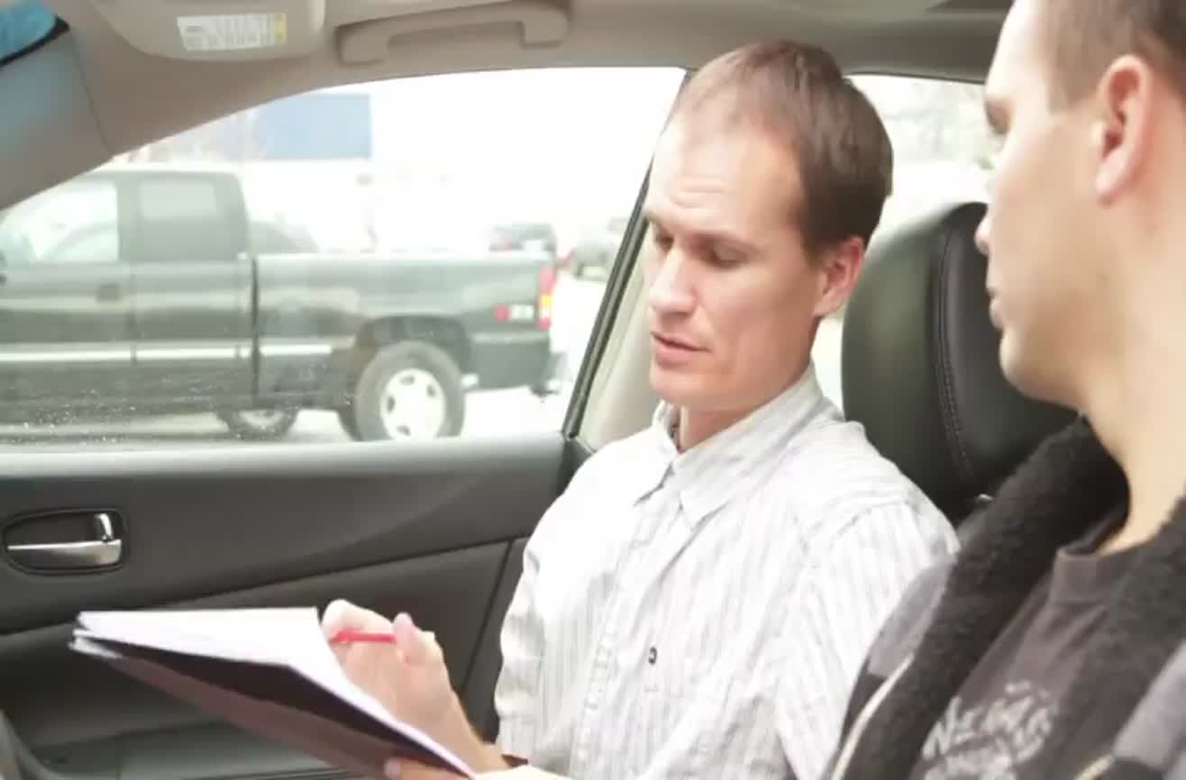 Adults impersonating how a kid would teach a friend to drive.