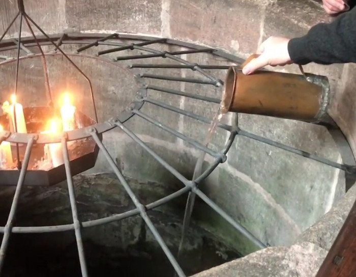 Pouring water down a 50-meter well.