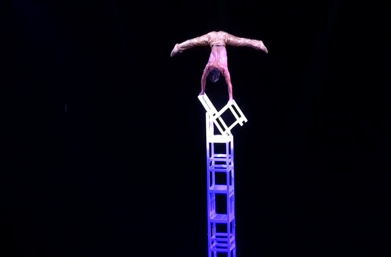 Skilled acrobat from Beijing balances chair.