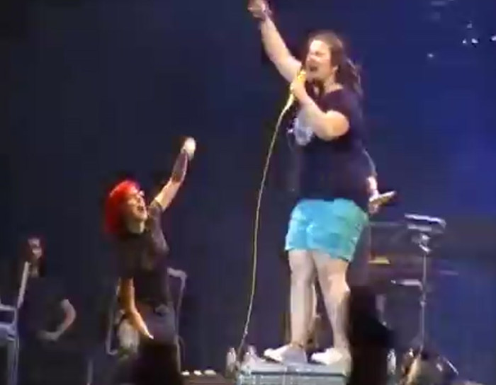 Fan falls on stage at concert, and the band all lies down next to her.