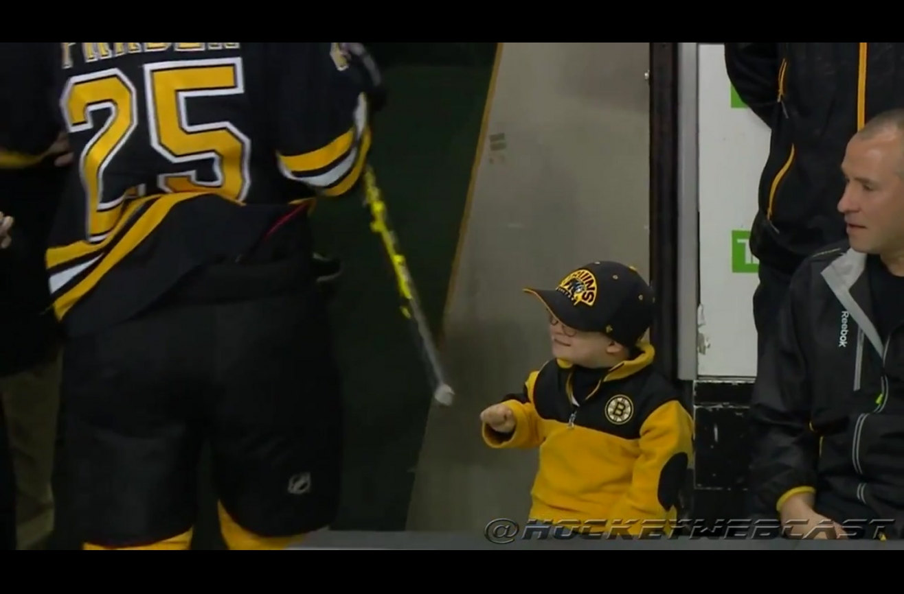 Excited young fan gets fist bumps from the Boston Bruins.