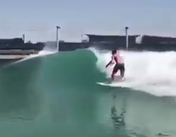 A specifically designed locomotive creates artificial waves for surfers.