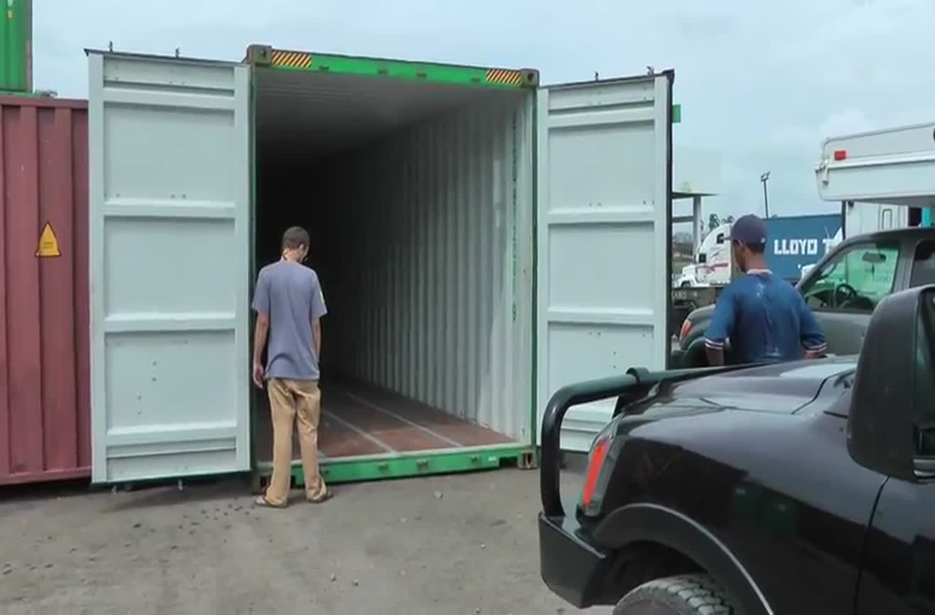 Loading a container with two trucks.