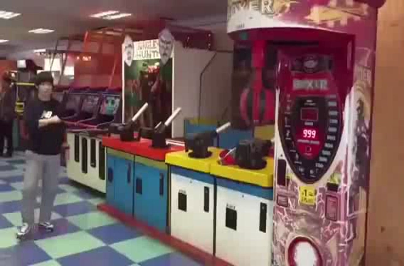 Man's spinning kick annihilates a punching bag arcade game.