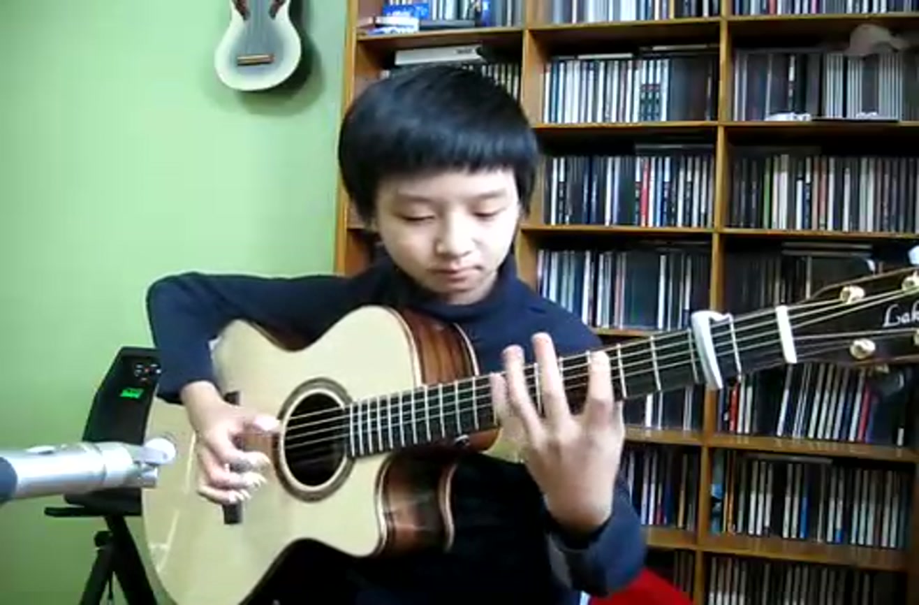 Child plays "Billie Jean" on guitar.