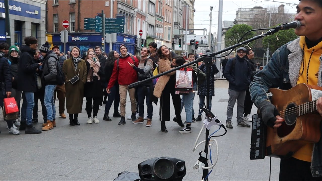 Crowd helps street performer sing Ed Sheeran.