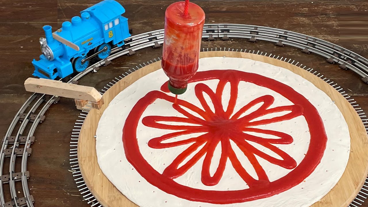 Clever pizza-making machine powered by toy train