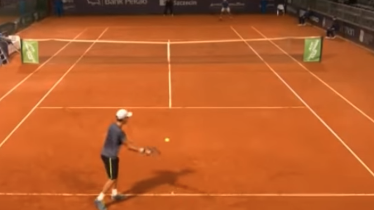 Tennis player bamboozles his opponent with underhand serve.