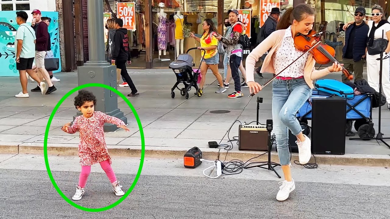 Adorable girl joins spectacular violin street performance.