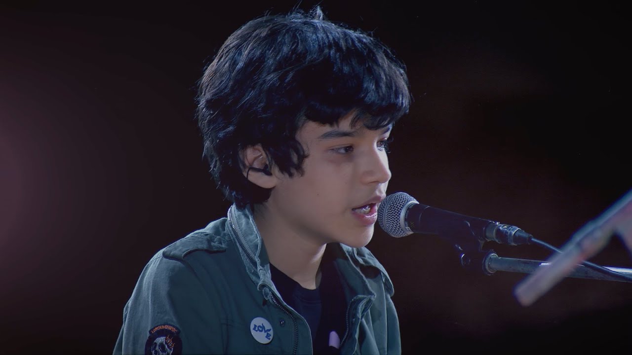 Autistic boy from viral video performs original song with Coldplay.