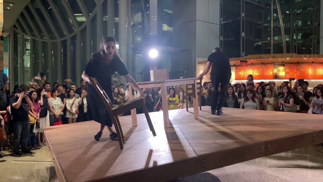 Actors somehow perform while balancing on platform.
